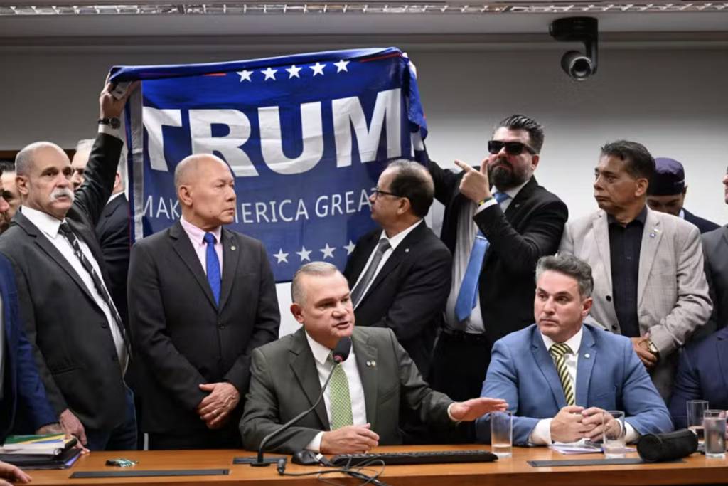 Deputados do PL exibem bandeira de Trump em comissão e expõem racha interno